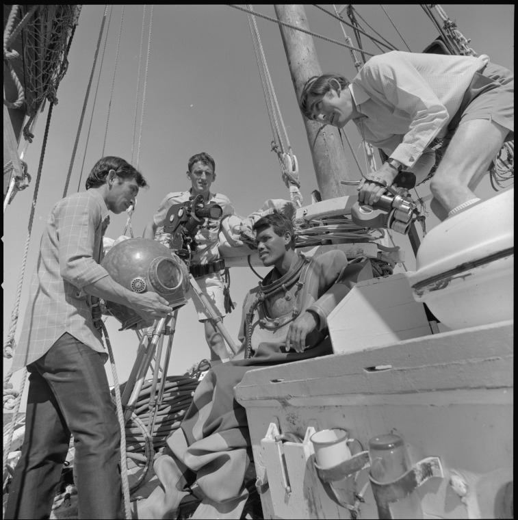 Filming a pearl diver as he is helped into a deep sea diving suit - JPG ...
