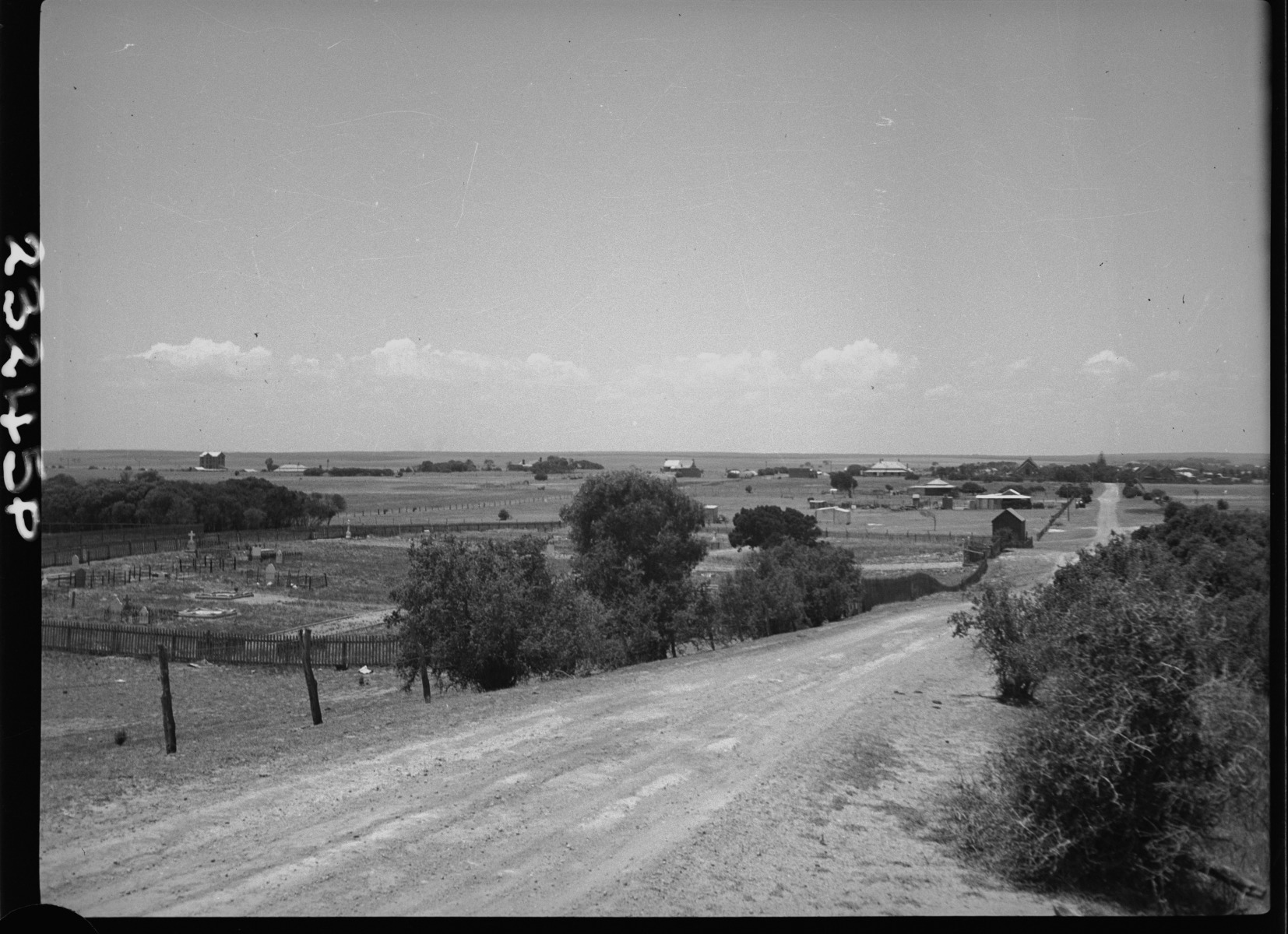 Cemetery by road leading into country town, probably Church Street ...