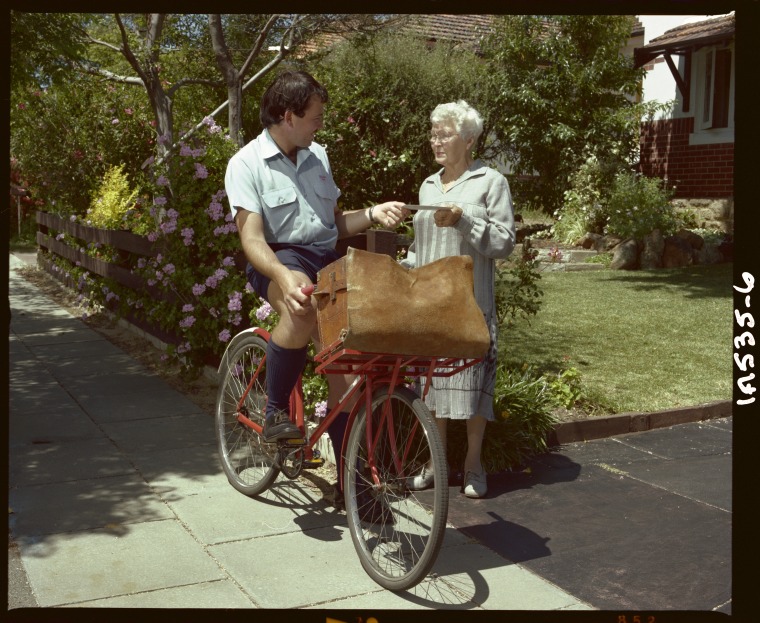 Postman on bicycle delivering mail to a lady - JPG 171.3 KB