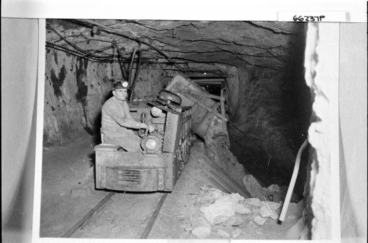Electric locomotive and driver in mineshaft at Big Bell Gold Mine ...