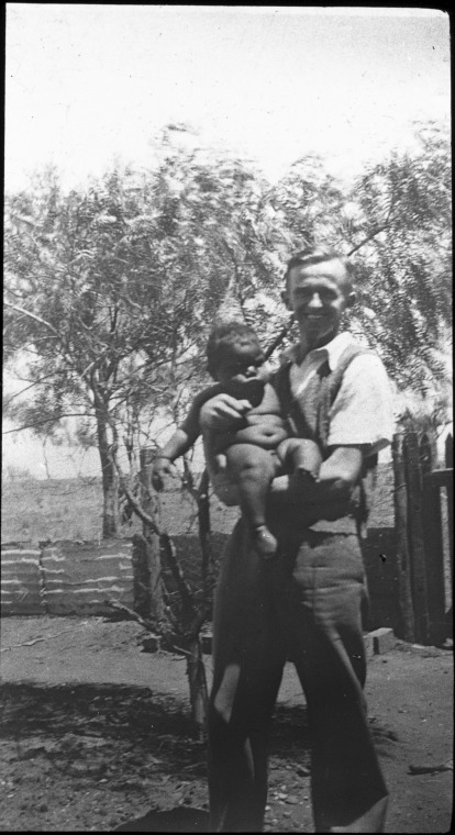 Preston Walker with a baby at Mt Margaret Mission. - JPG 95.2 KB