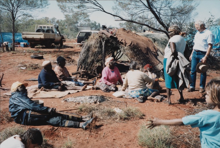 Aboriginal group around a campfire fire beside a humpy, location ...