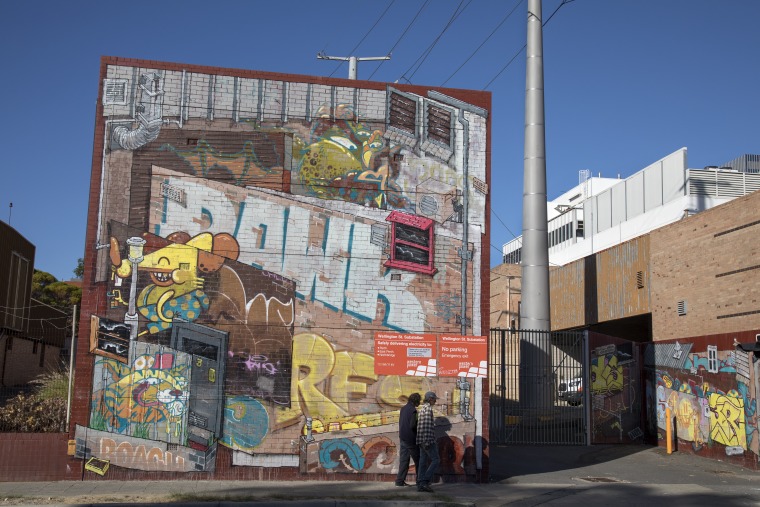Aboriginal men walk past the graffiti covered Moore Street facade of ...
