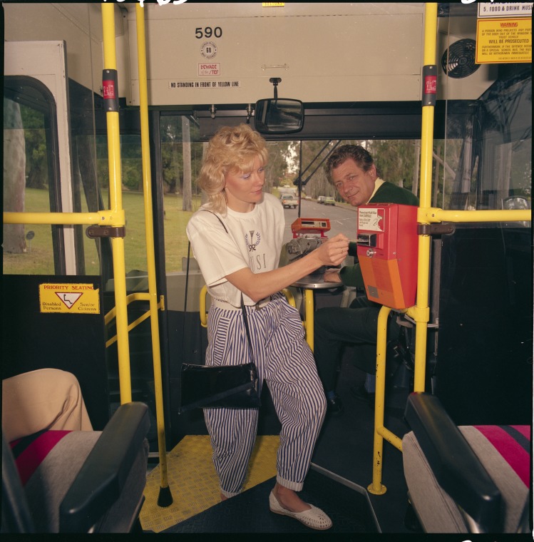 A woman inserts a MultiRider into the validating machine on a ...