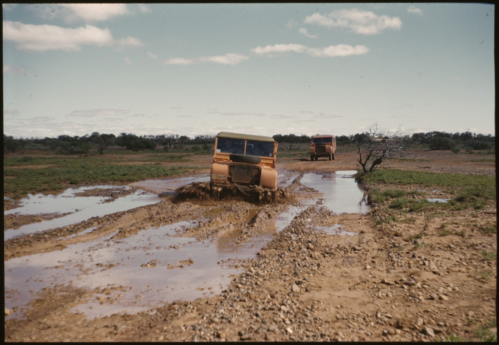 Land Rovers, probably WAPET vehicles, on a flooded dirt road on Mount ...